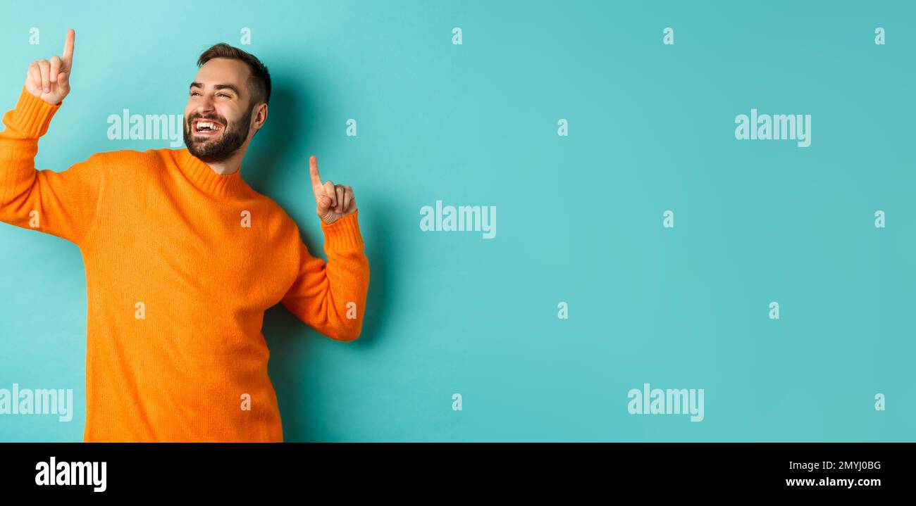 Handsome man celebrating, feeling winner, pointing fingers up and do ...