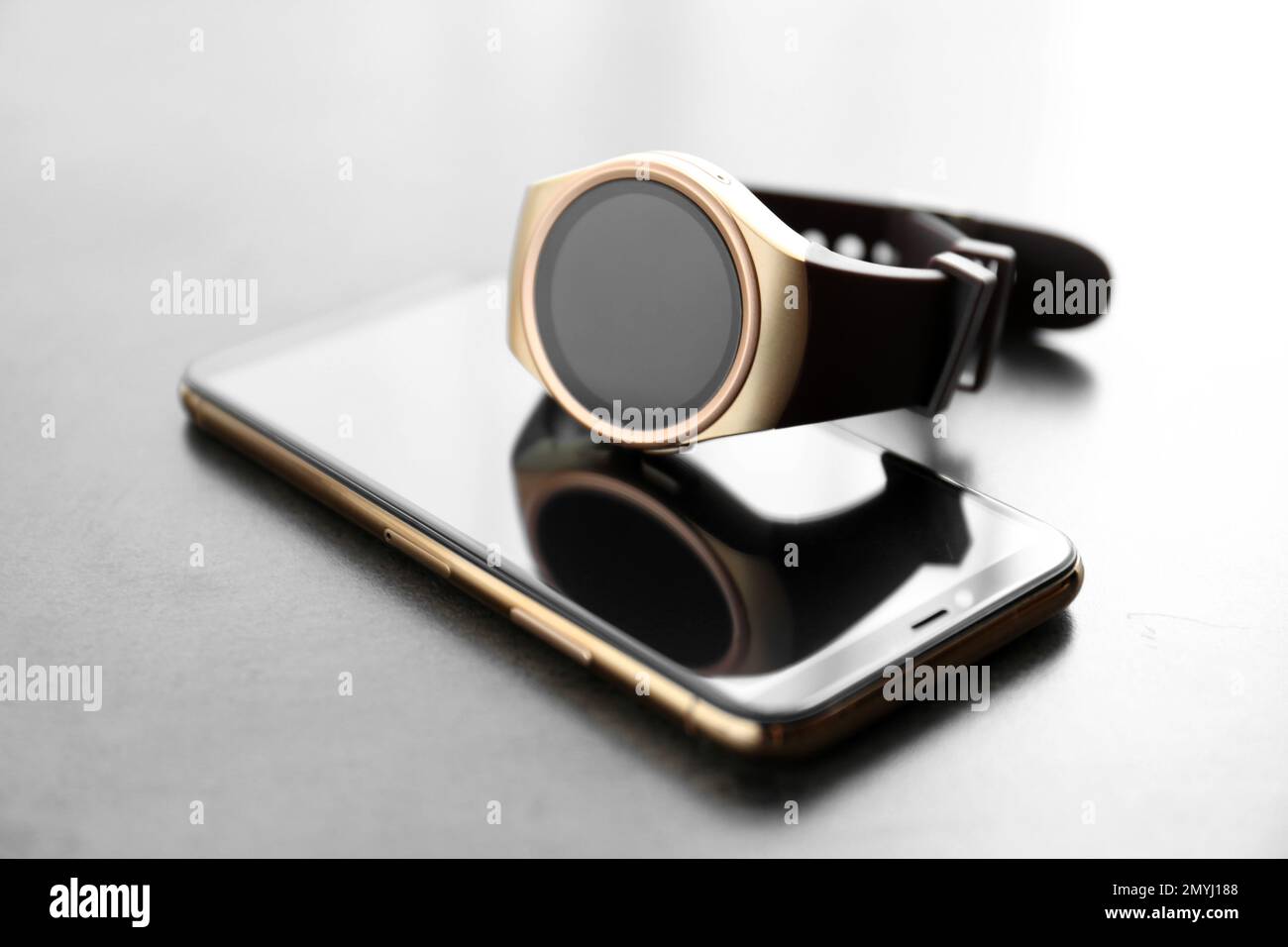Stylish smart watch and phone on grey table, closeup Stock Photo - Alamy
