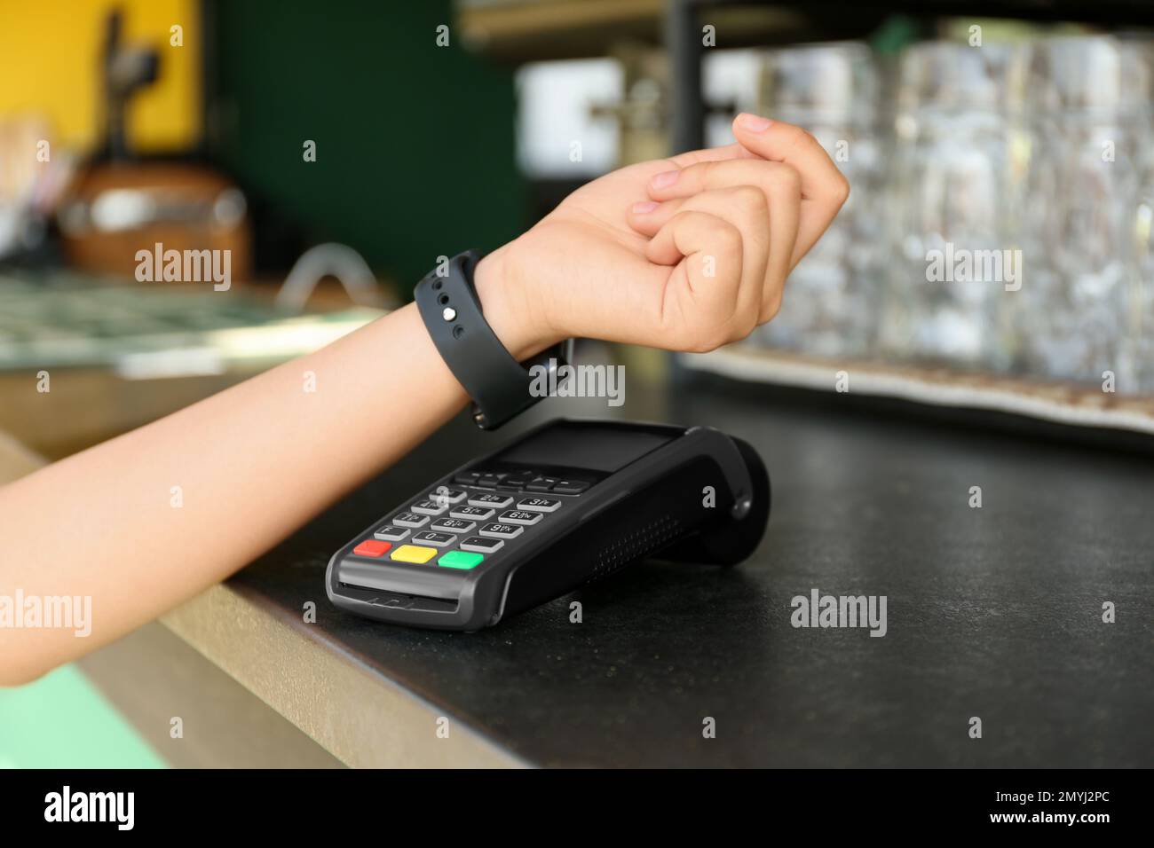 Woman using smartwatch for contactless payment at bar counter, closeup ...
