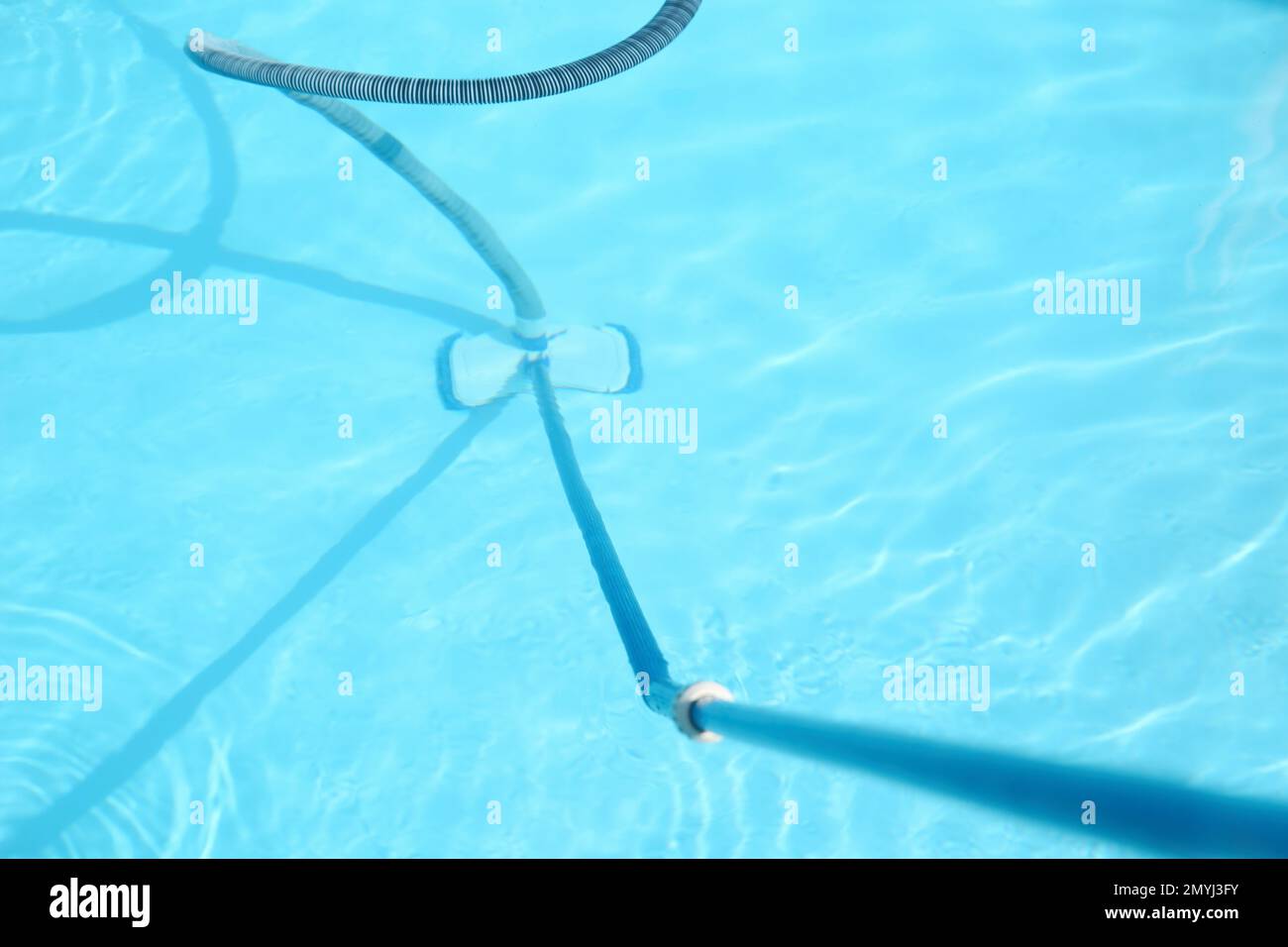 Cleaning outdoor swimming pool with underwater vacuum Stock Photo - Alamy