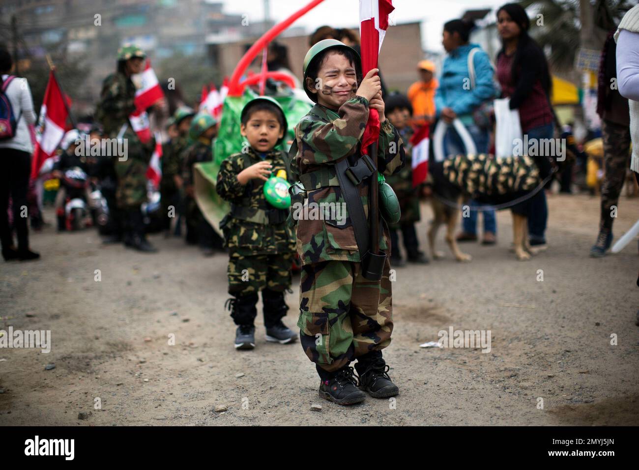 A boy in camouflage cries while holding the Peruvian flag during a ...