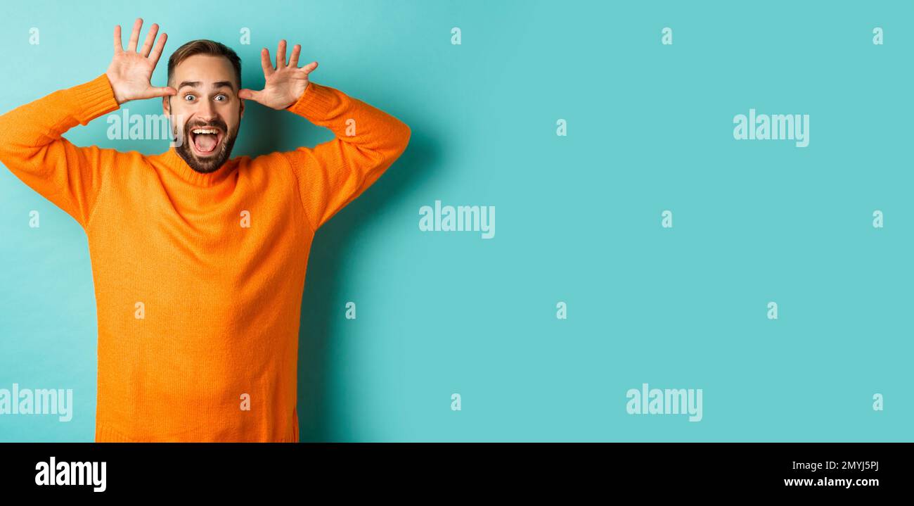 Image of handsome caucasian man making funny faces, mocking someone and ...