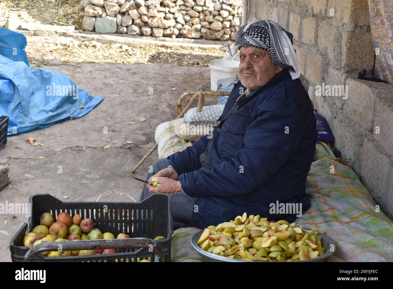 An elderly man sits on a cot outside his northern Iraqi village home ...