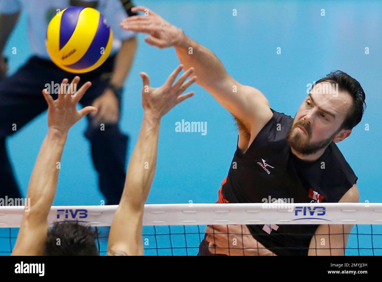 Nicholas Hoag of Canada spikes against Venezuela during their Men's ...