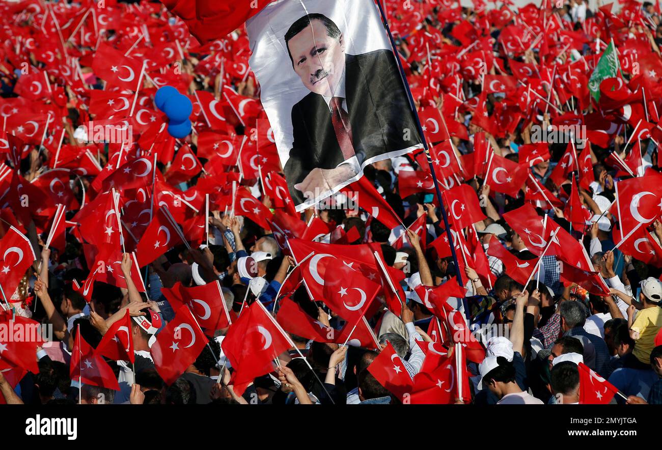 People wave national flags and an image of Turkey's President Recep ...