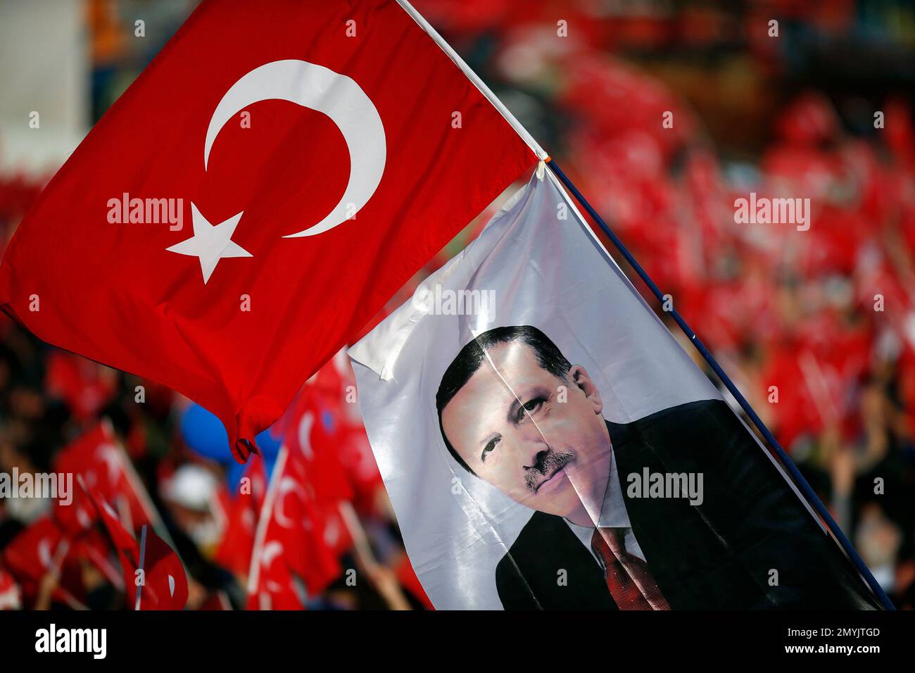People wave national flags with an image of Turkey's President Recep ...