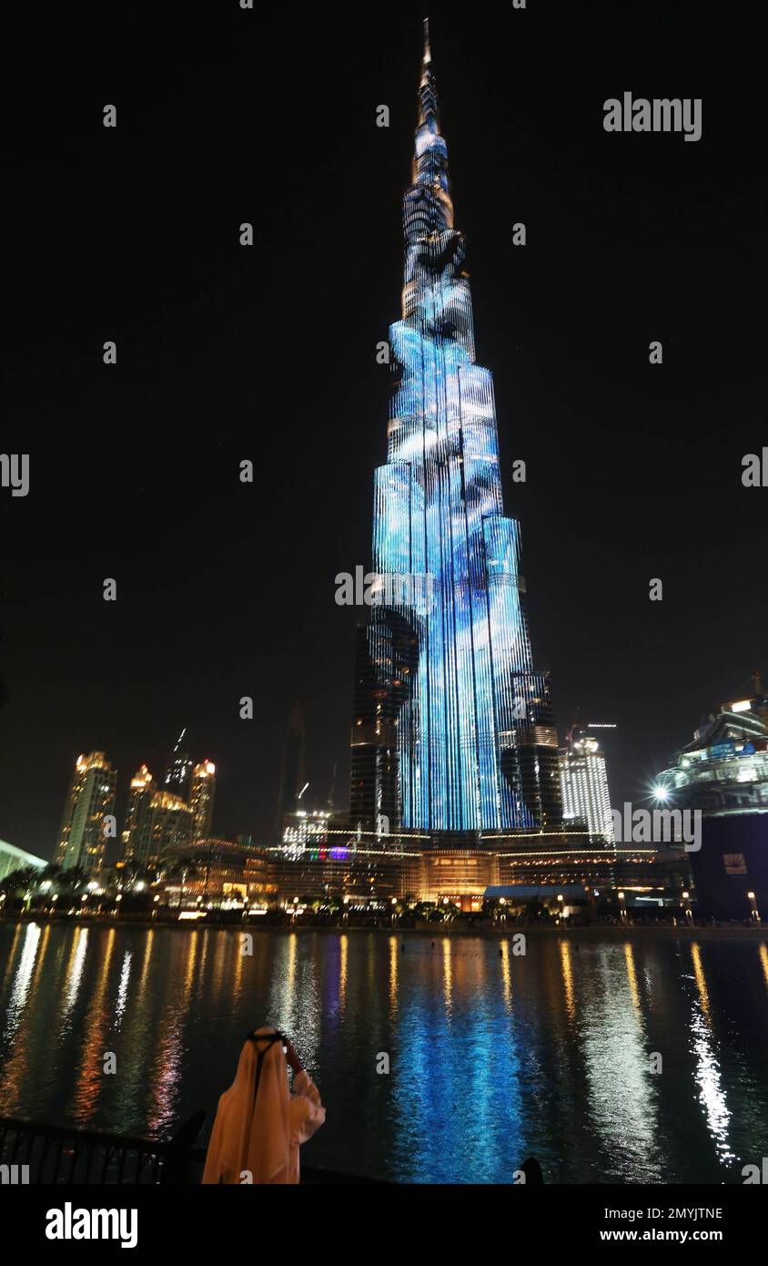 An Emirati man in traditional robes watches an LED light show on the ...