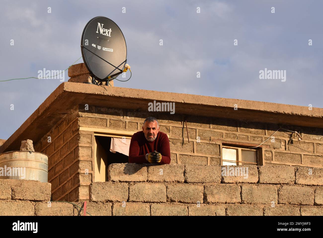A Kurdish man leaning on the balcony of his home in a Northern Iraqi ...