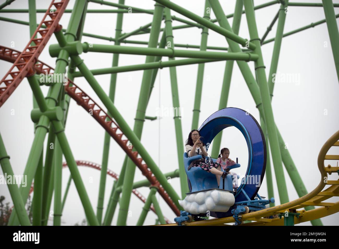 Visitors ride a sightseeing ride on an elevated track at the Nanchang ...