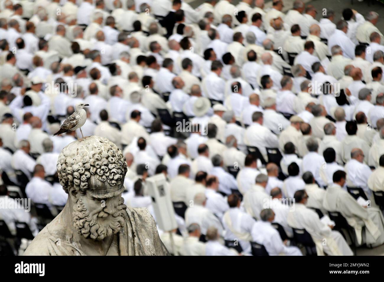 A seagull sits on the statue of St. Peter which towers over deacons ...