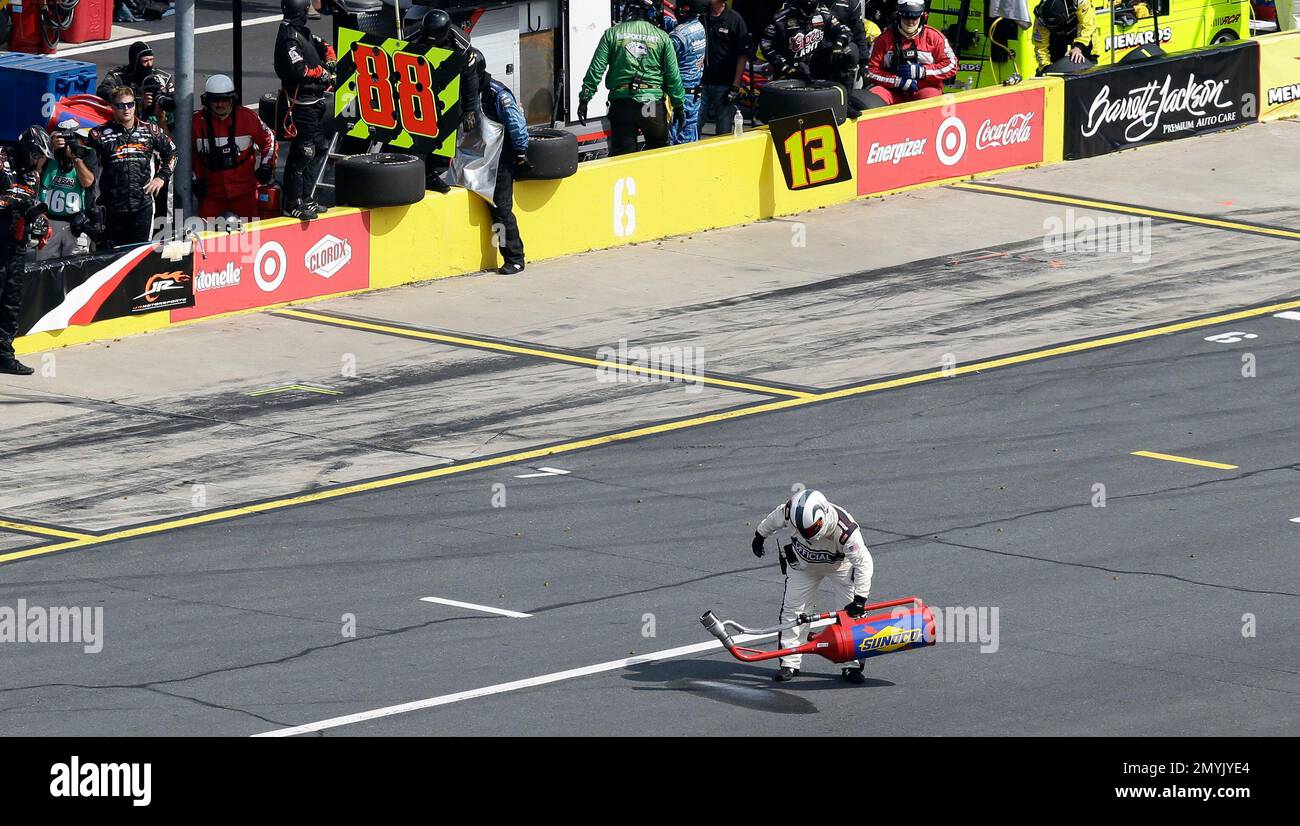 An official picks up a gas tank from pit road during the NASCAR Xfinity ...