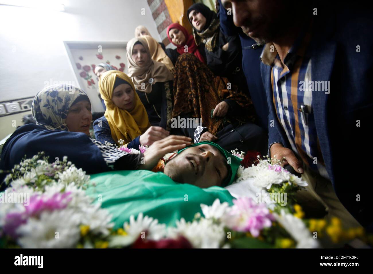 The mother, left, and relatives gather around the body of Palestinian ...