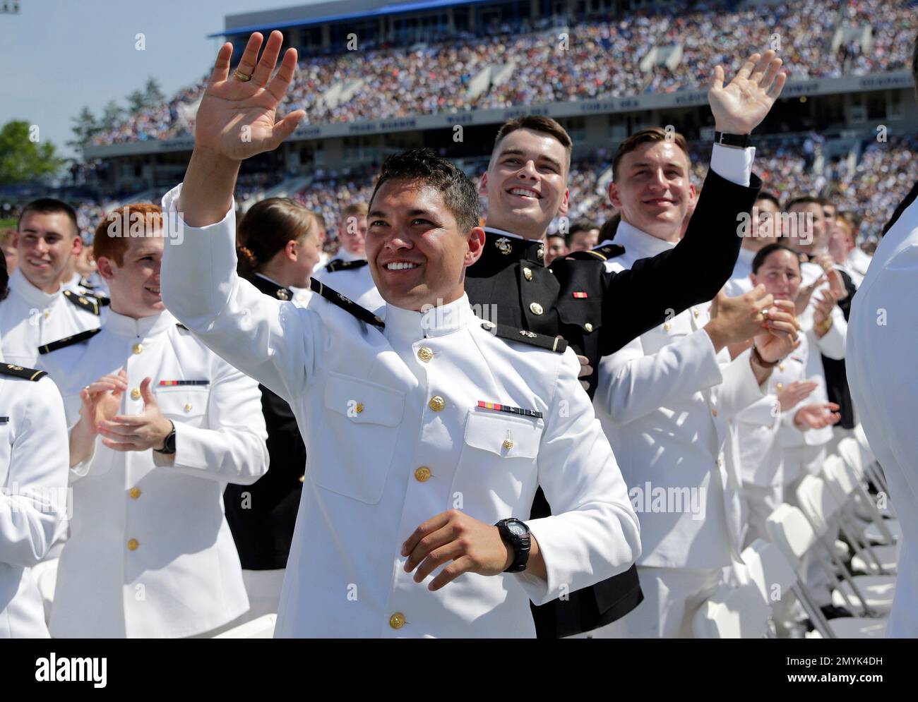 Graduating U.S. Naval Academy Midshipmen wave to onlookers in the ...