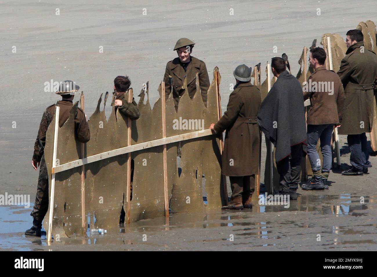 Actors wait on the beach before filming a scene for the film, "Dunkirk ...