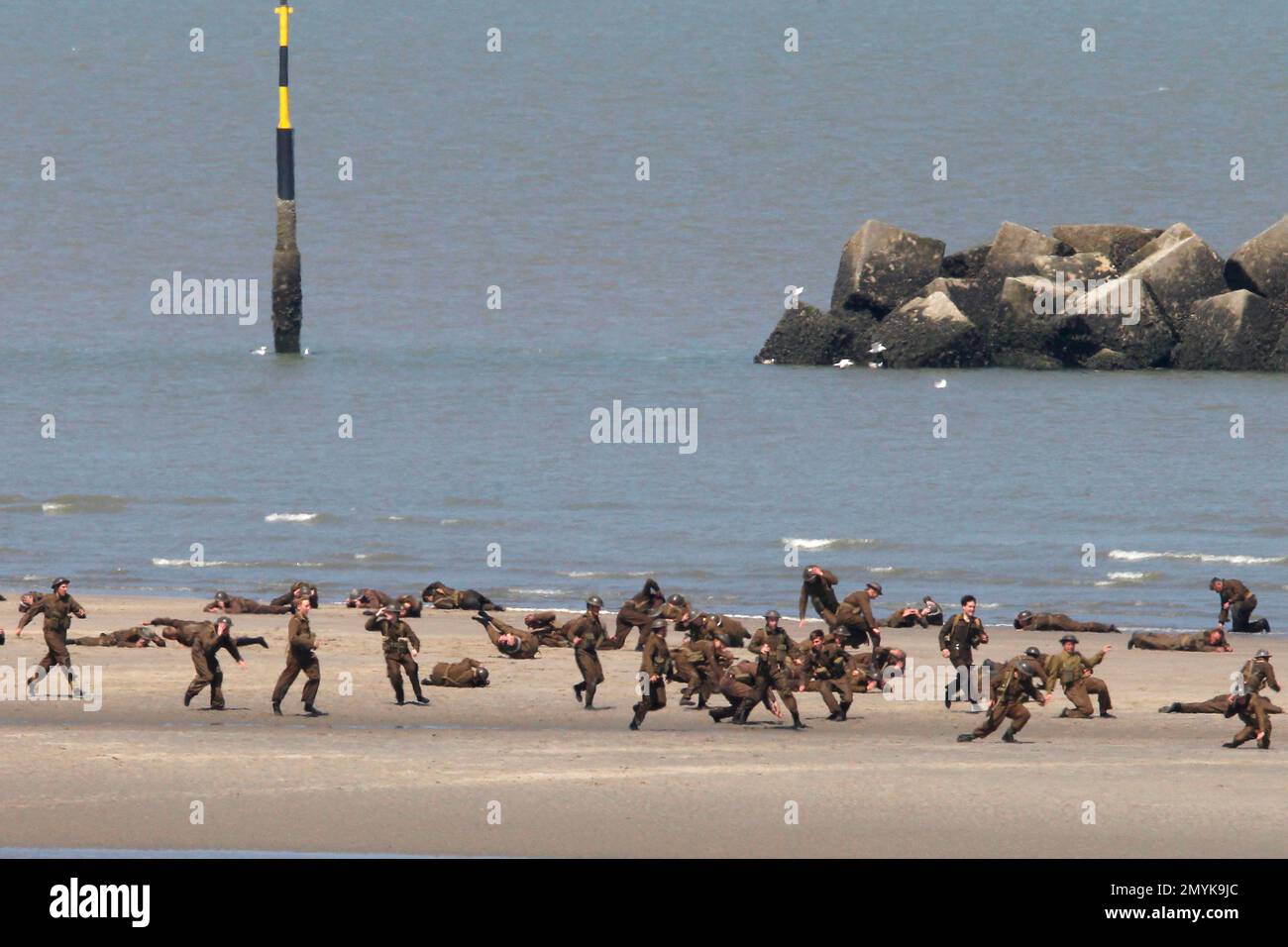 Actors perform on the beach during filming a scene for the film ...