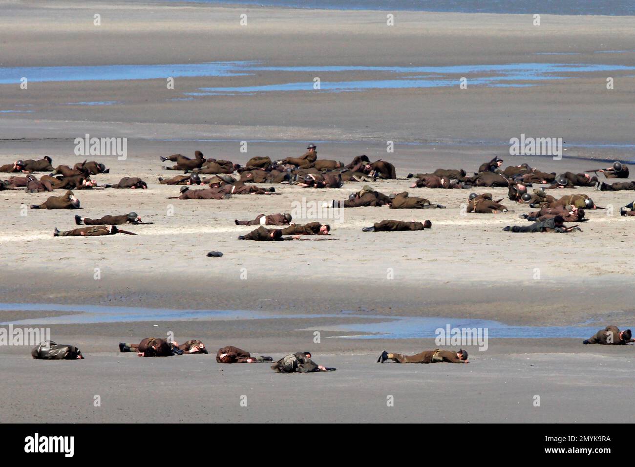 Actors perform on the beach during filming a scene for the film ...