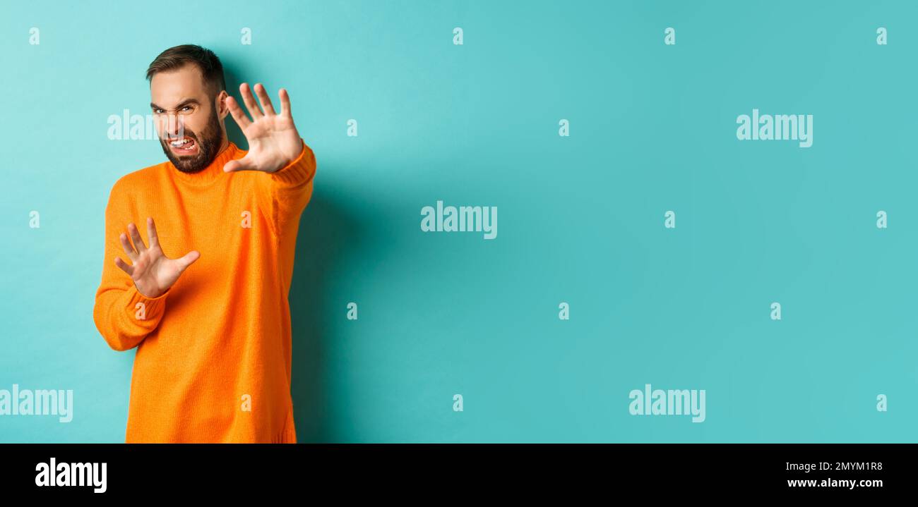 Disgusted man cringe and extending hands in protection, begging for ...