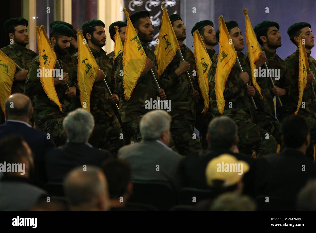 Hezbollah fighters hold their group flags as they parade during a ...