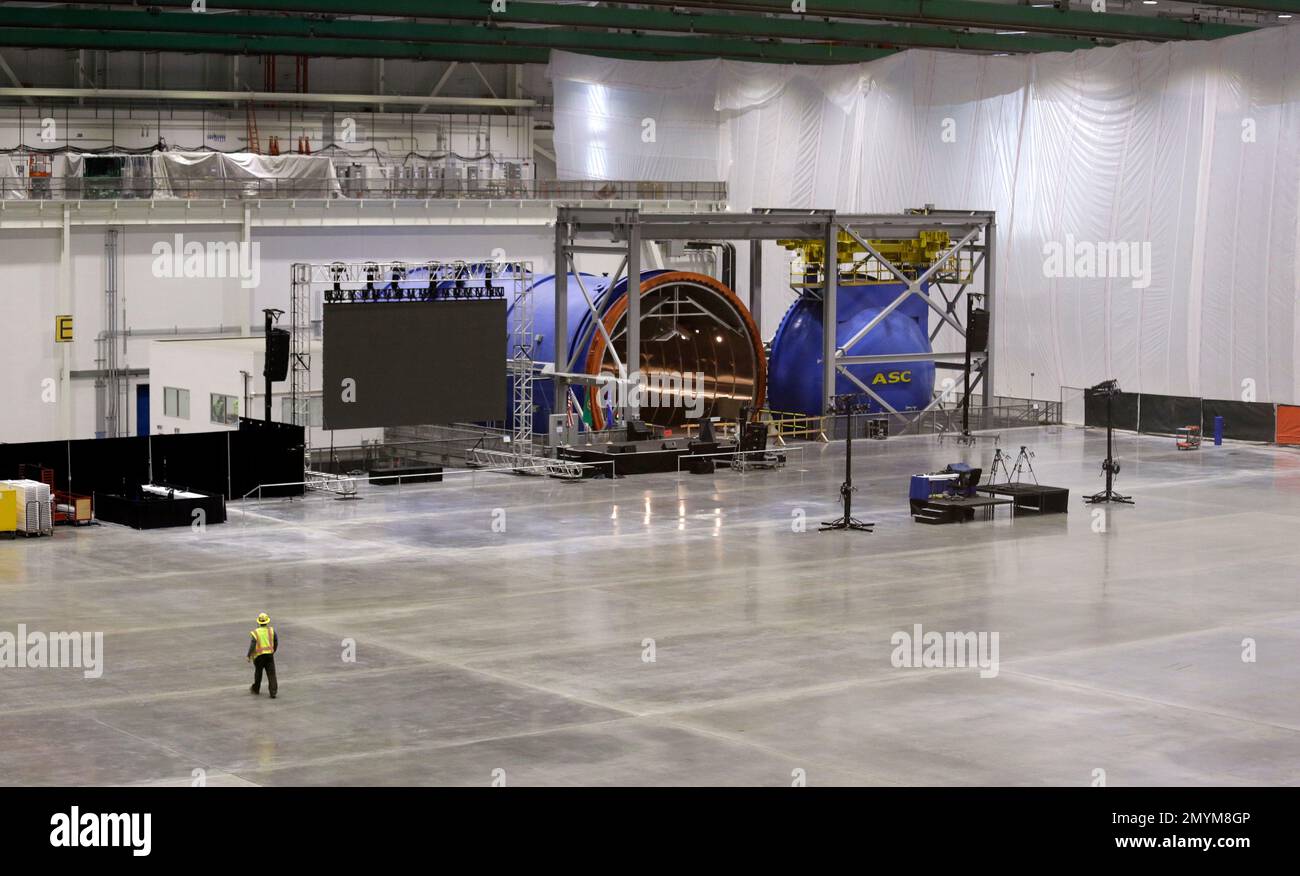 A worker walks in view of a massive autoclave that will be used to bake ...