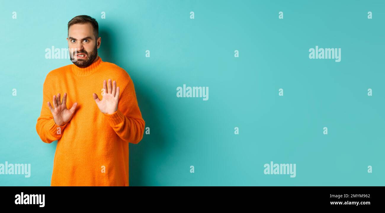 Alarmed guy shaking hands in rejection, declining and stepping away ...