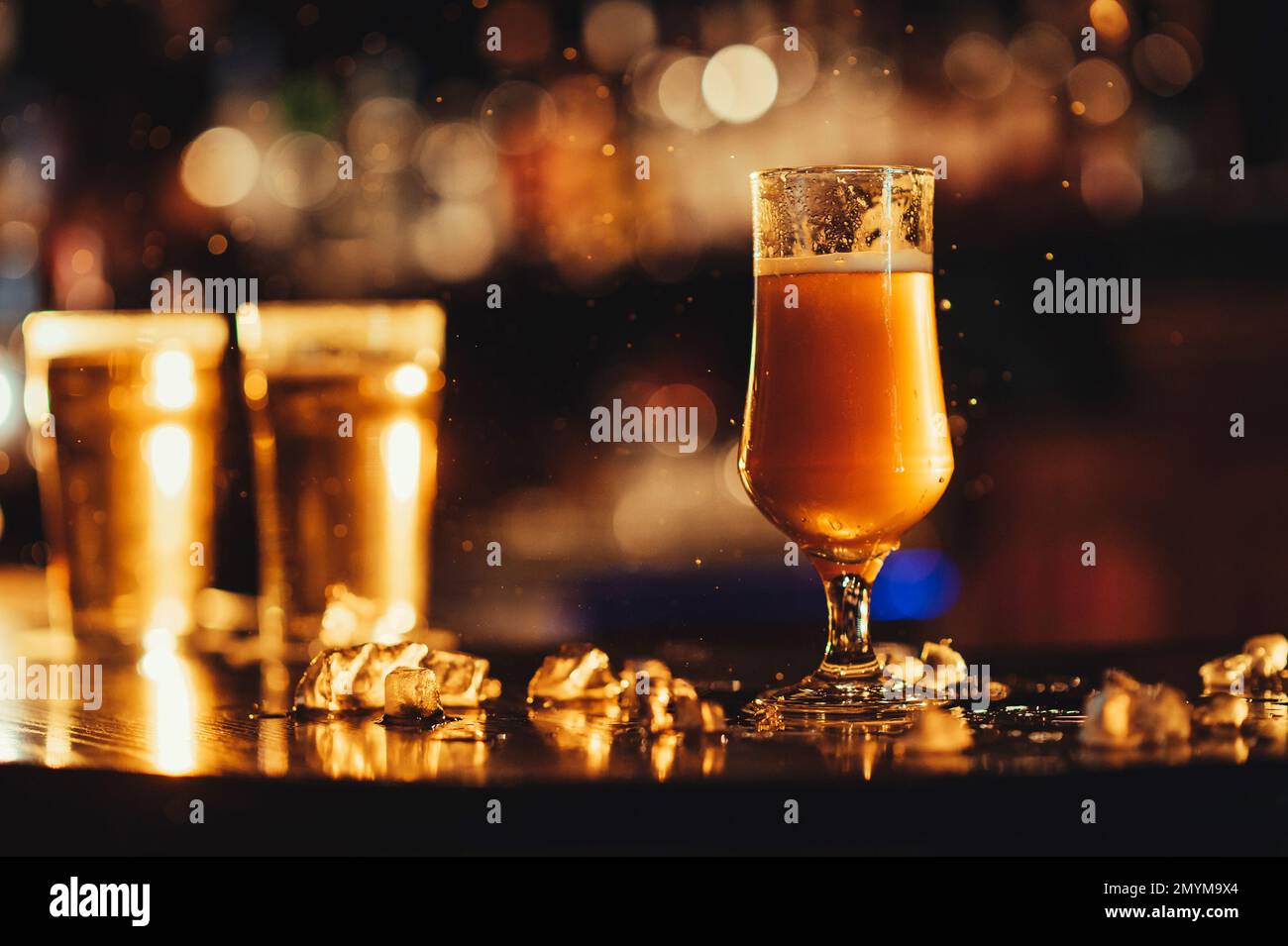 glass of light unfiltered draft beer with on bar counter with drops of ...