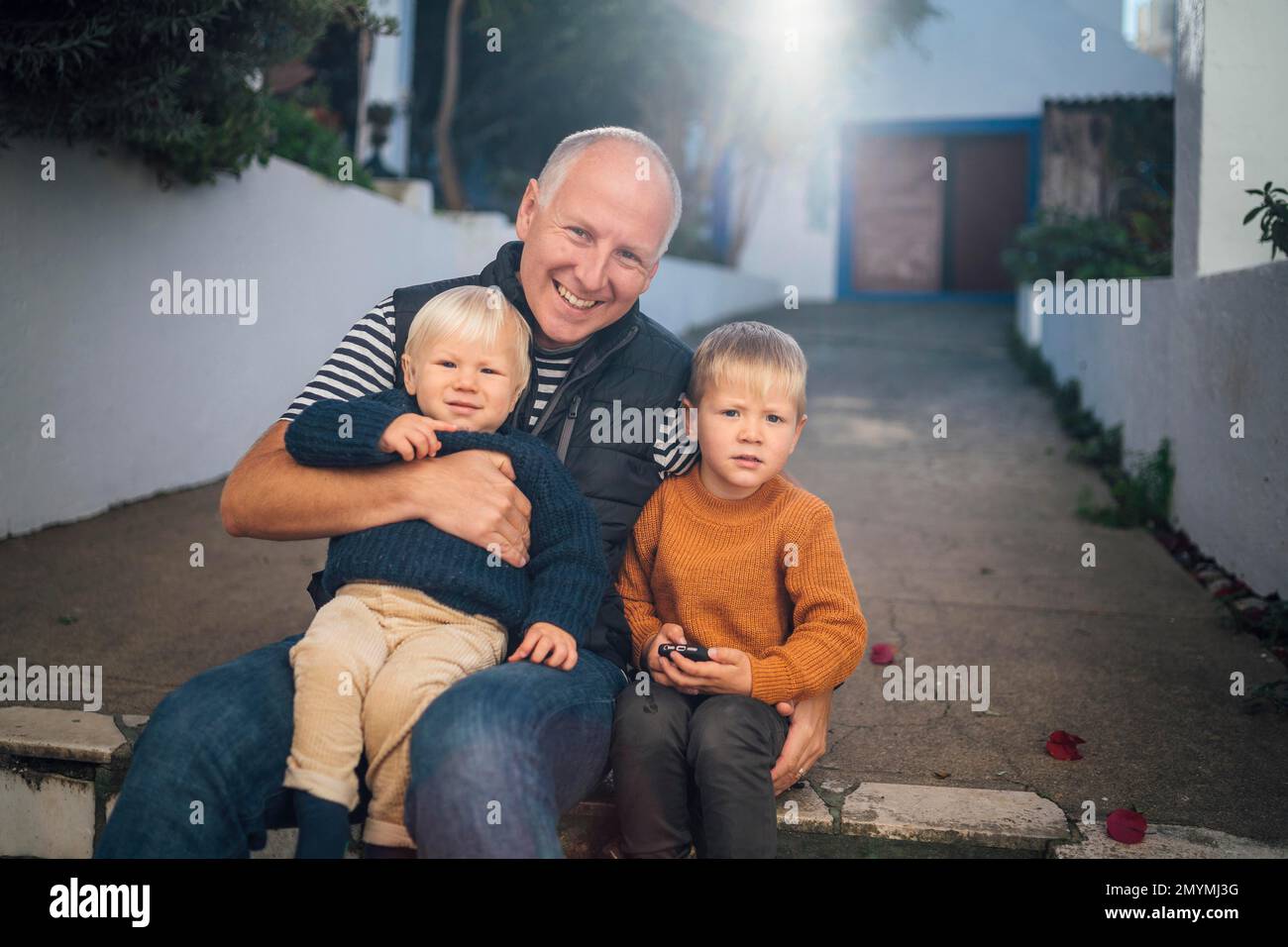 Father with his two sons hugging each other outdoor during fall Stock ...