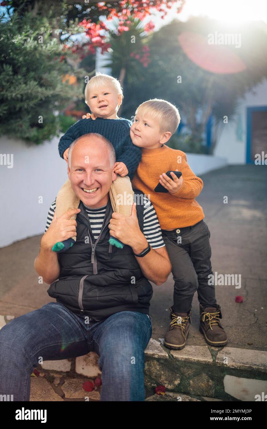 Father with his two sons hugging each other outdoor during fall Stock ...