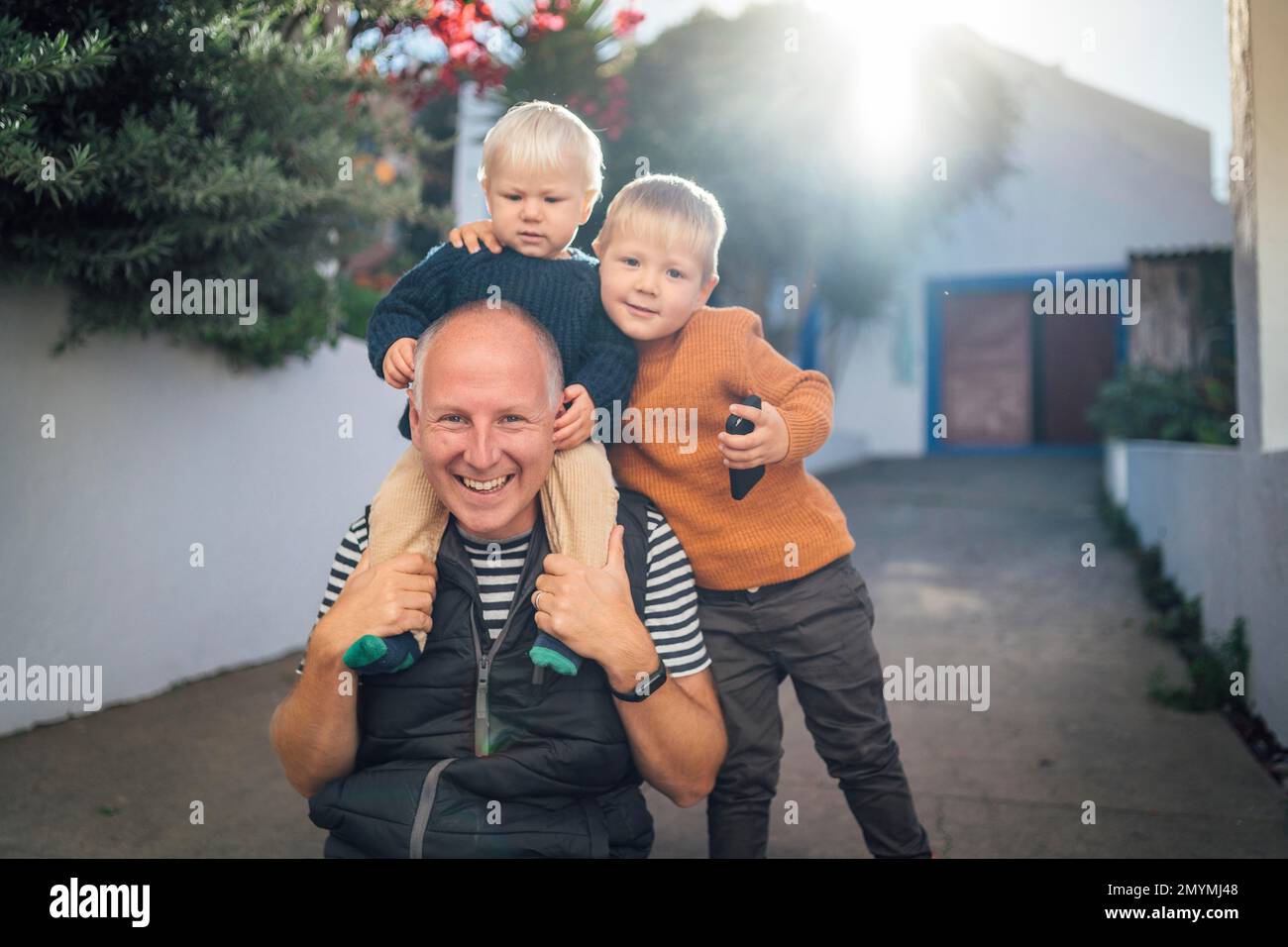 Father with his two sons hugging each other outdoor during fall Stock ...