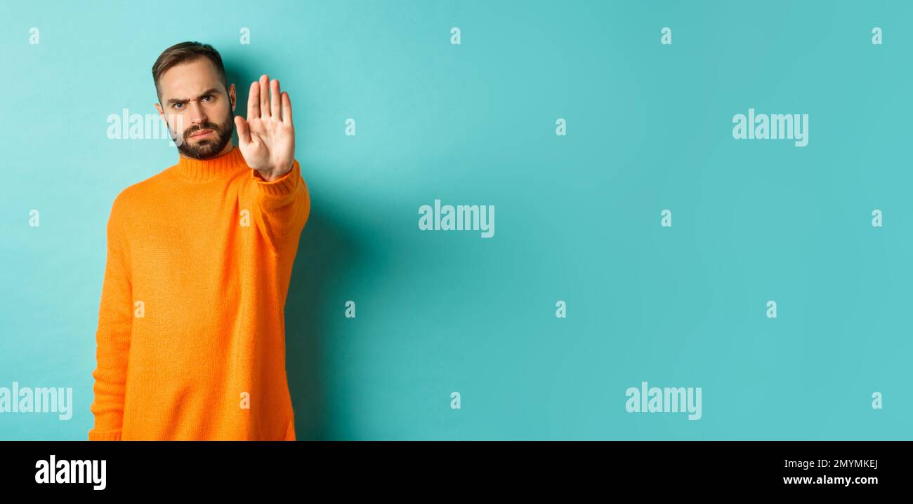 Serious frowning man showing stop gesture, telling no, prohibit and ...