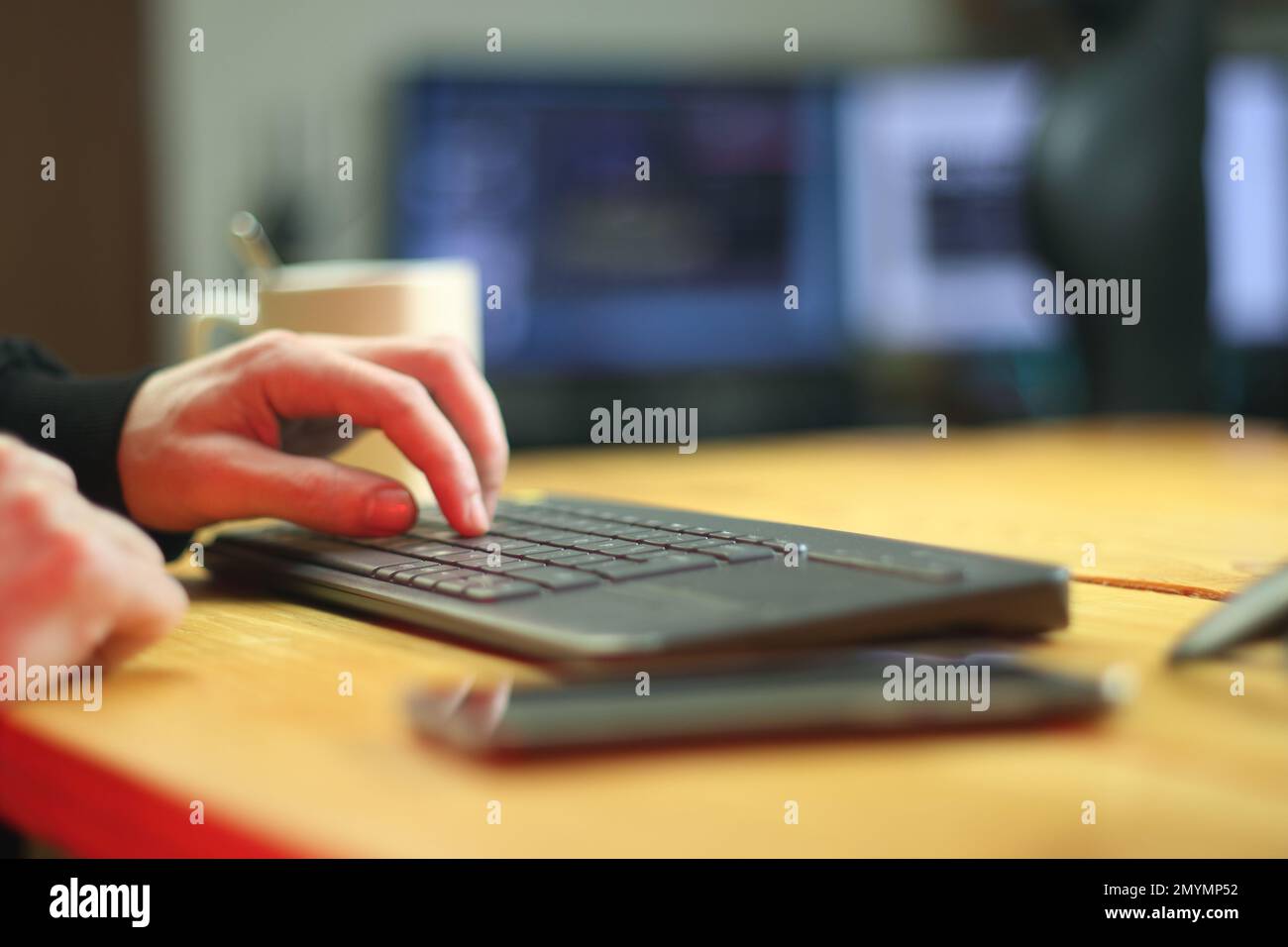 person typing on keyboard to tv by person on table and colored ...