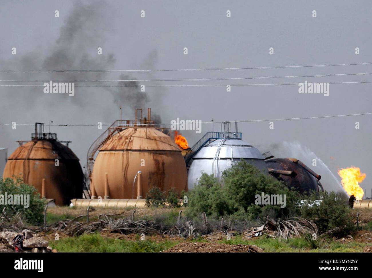 Iraqi firefighters try to extinguish a fire at a natural gas plant in ...