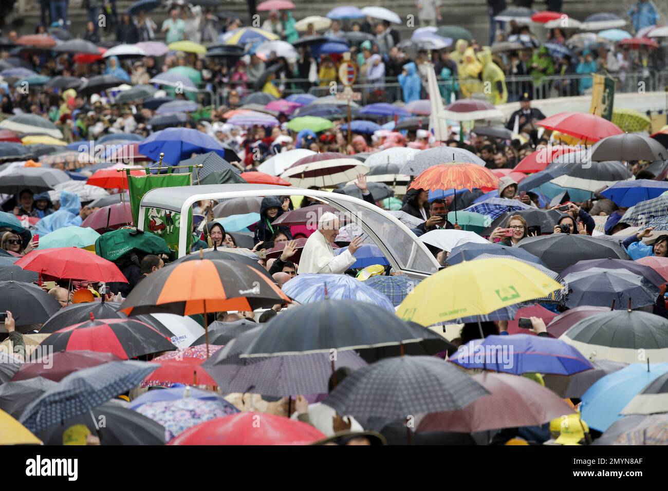 Pope Francis is driven through the crowd as he arrives for an audience ...