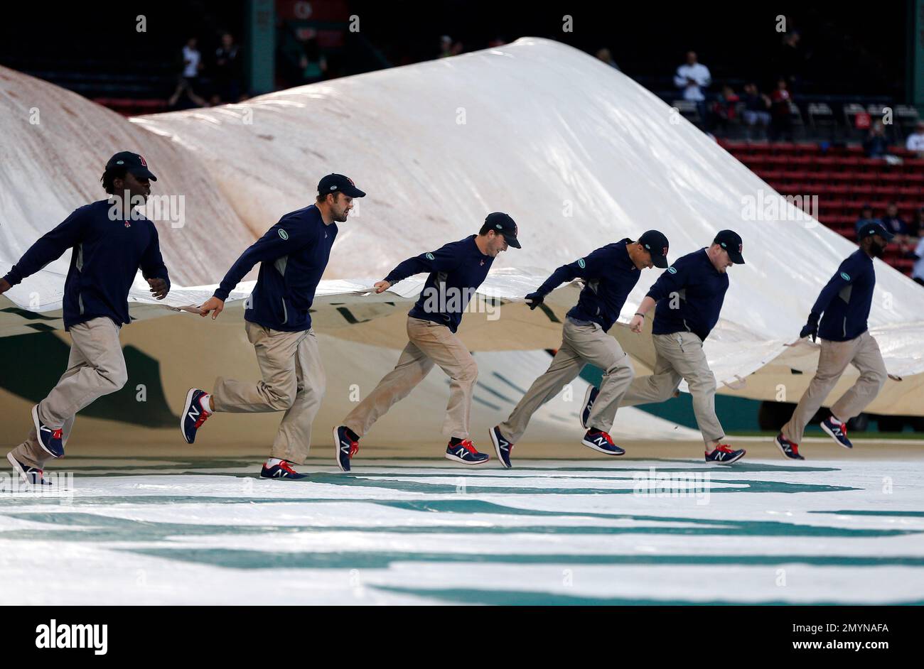 The Fenway Park grounds crew removes the tarp before a baseball game ...