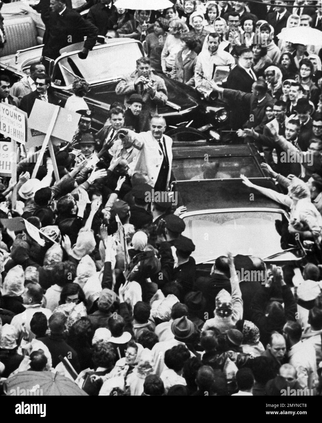 President Lyndon B. Johnson rides outside his limousine on the running ...