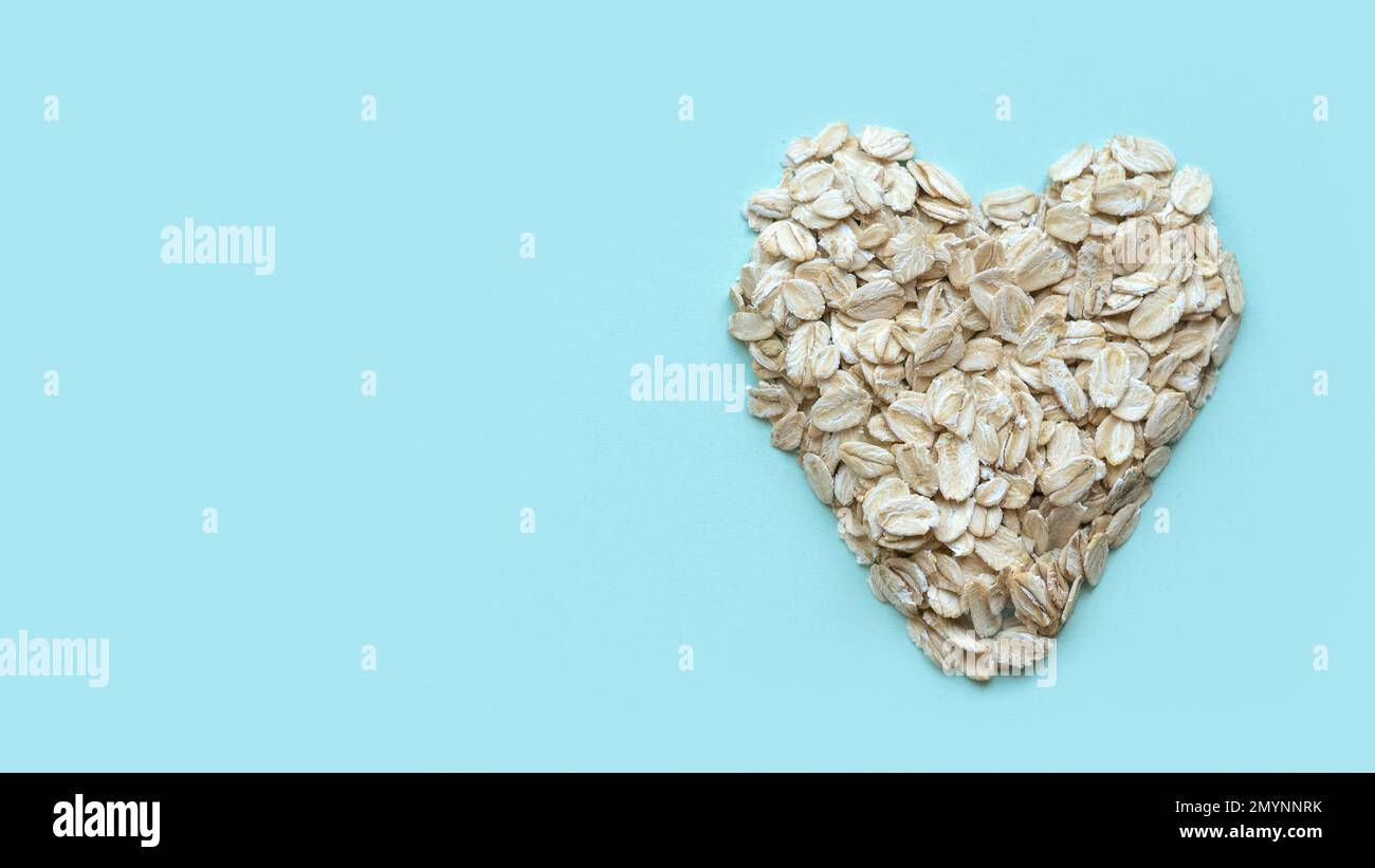 Dry rolled oatmeal cereal. An oat flakes with a heart or love shape on ...