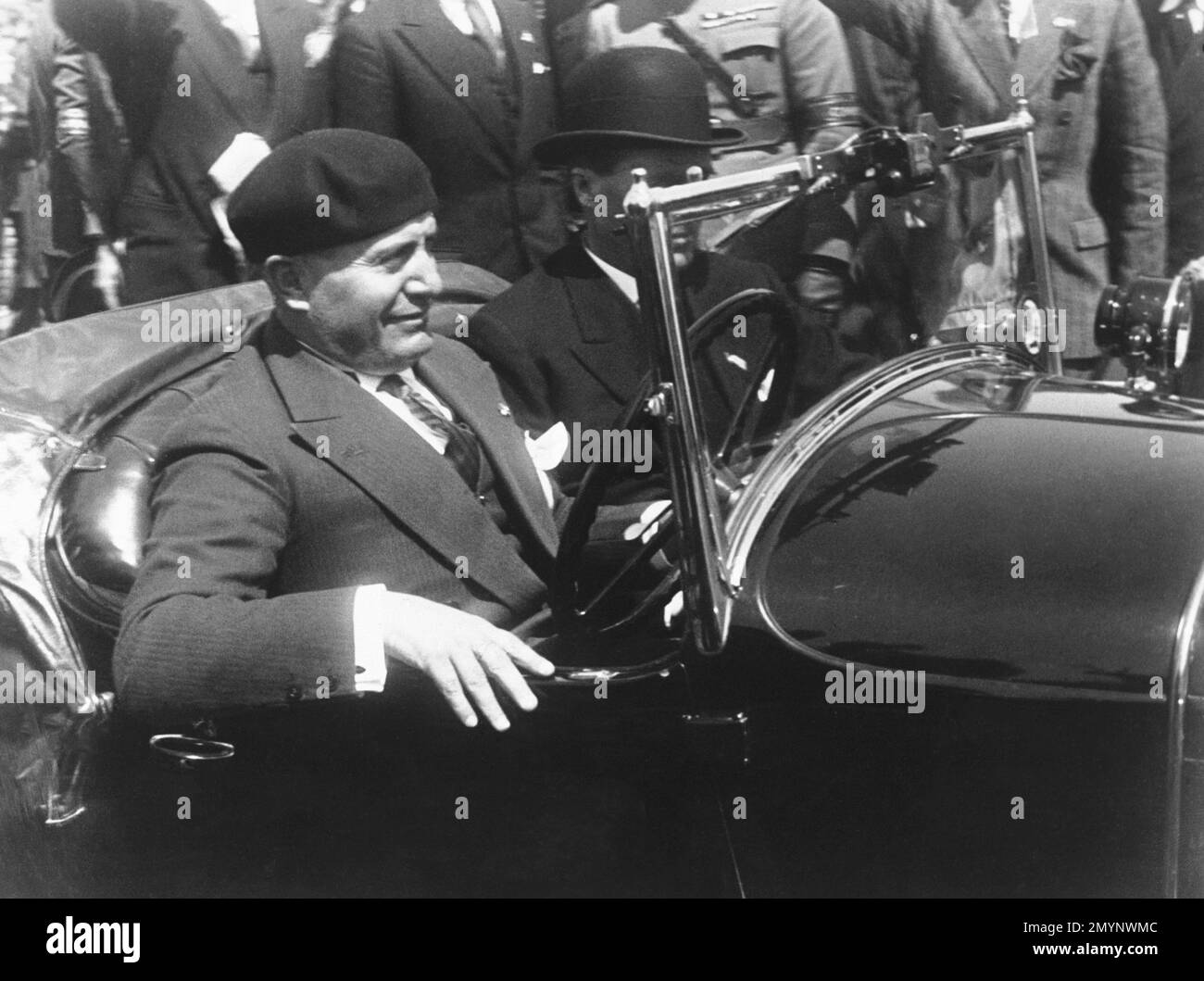 Italian Benito Mussolini, wearing a beret, arrives by car to open a new ...