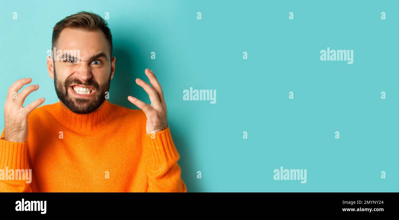 Close-up of angry caucasian man looking mad, grimacing and shaking ...