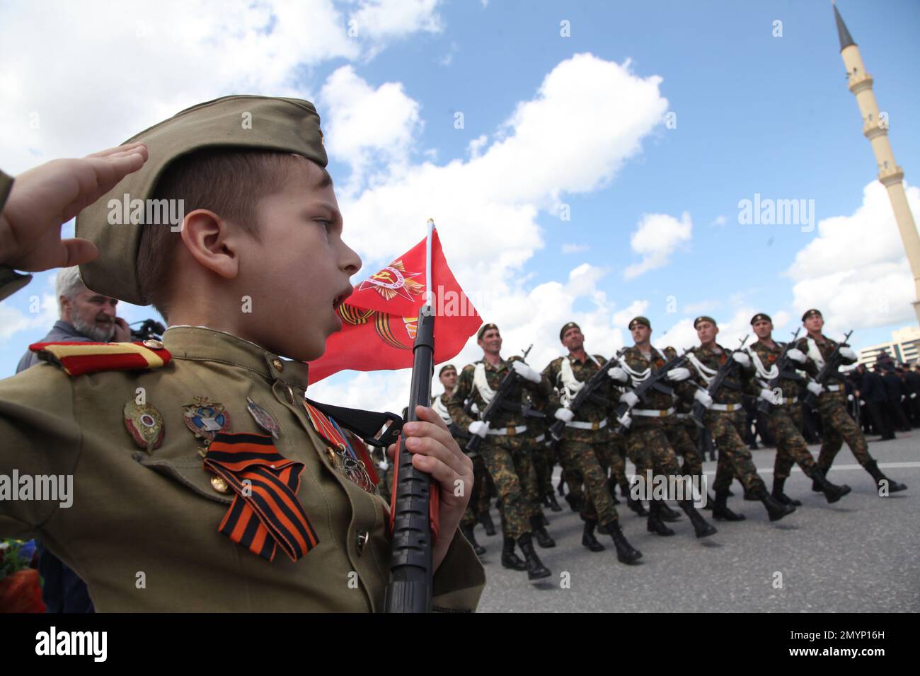 A Chechen boy dressed in a WWII era Soviet uniform, salutes during ...
