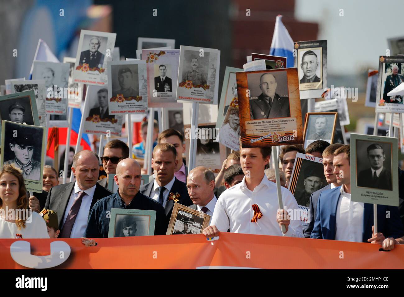 Russian President Vladimir Putin, center, holds a photograph of his ...