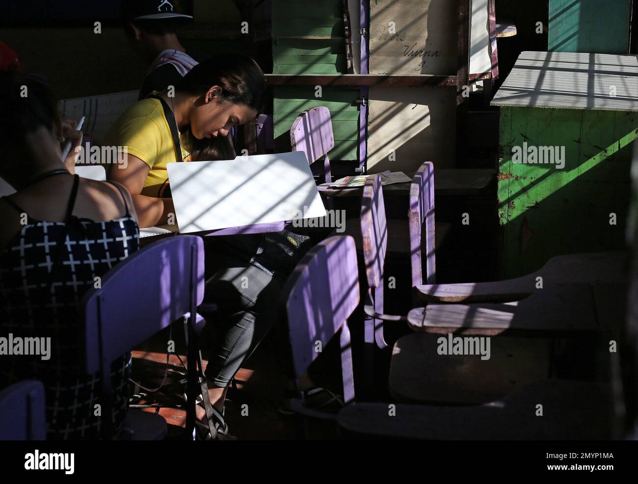 A Filipino woman votes at a polling center in Manila, Philippines on ...