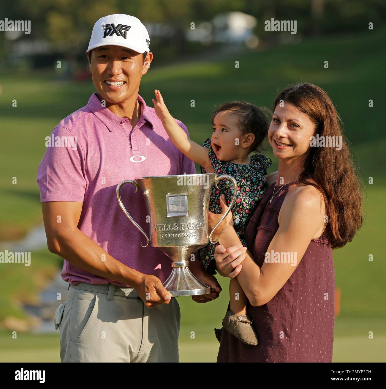 James Hahn, left, poses with the trophy and his wife Stephanie, right ...