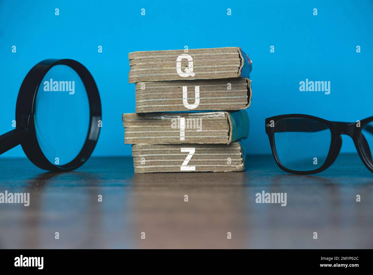 A Magnifying Glass Glasses And A Stack Of Book Written With Quiz On A Blue Background Stock 