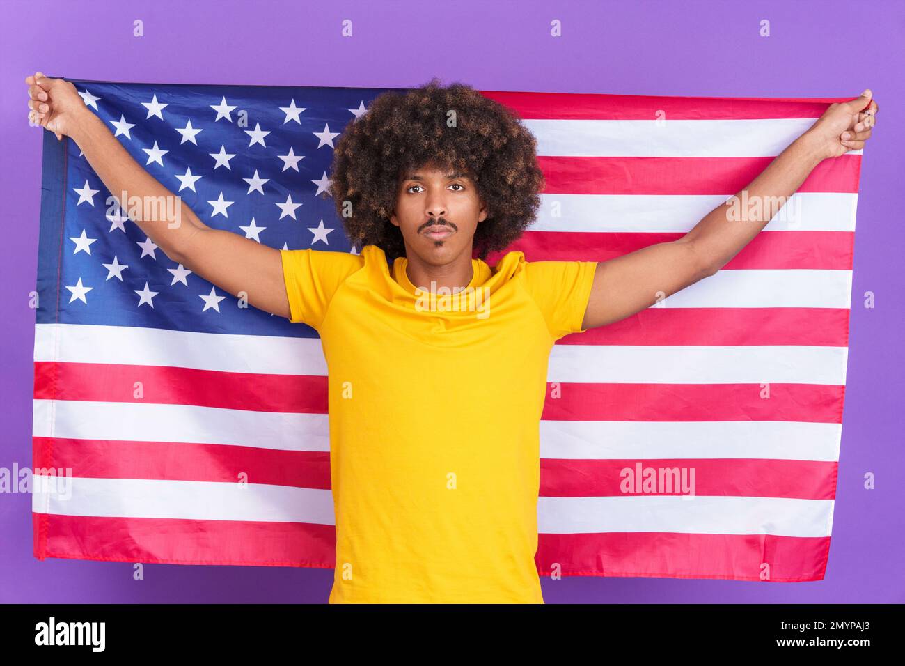 Serious african man raising a north america national flag Stock Photo ...