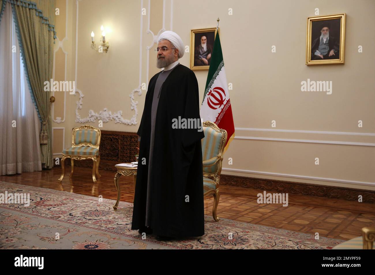 Iranian President Hassan Rouhani stands while waiting to welcome head ...