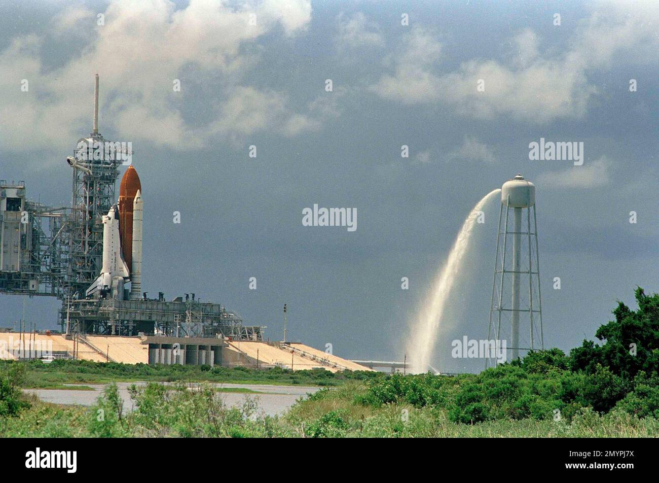 Water pours from a tower after the space shuttle orbiter Discovery is ...