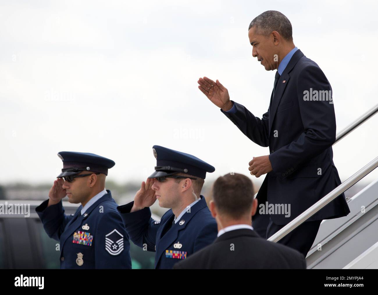 President Barack Obama salutes as he arrives on Air Force One at Bishop ...