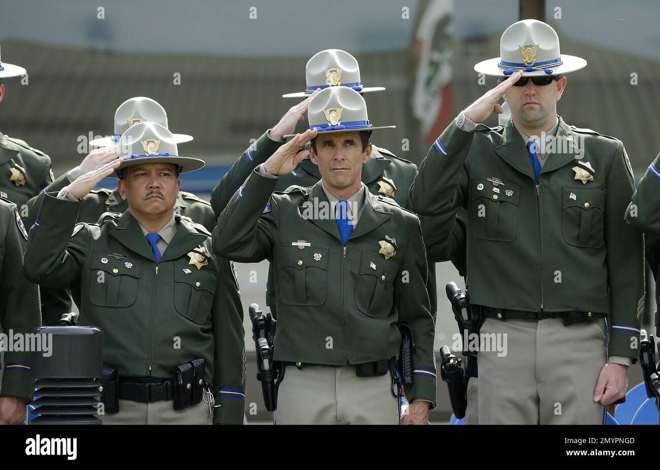 California Highway Patrol Officers salute as the flags are raised ...