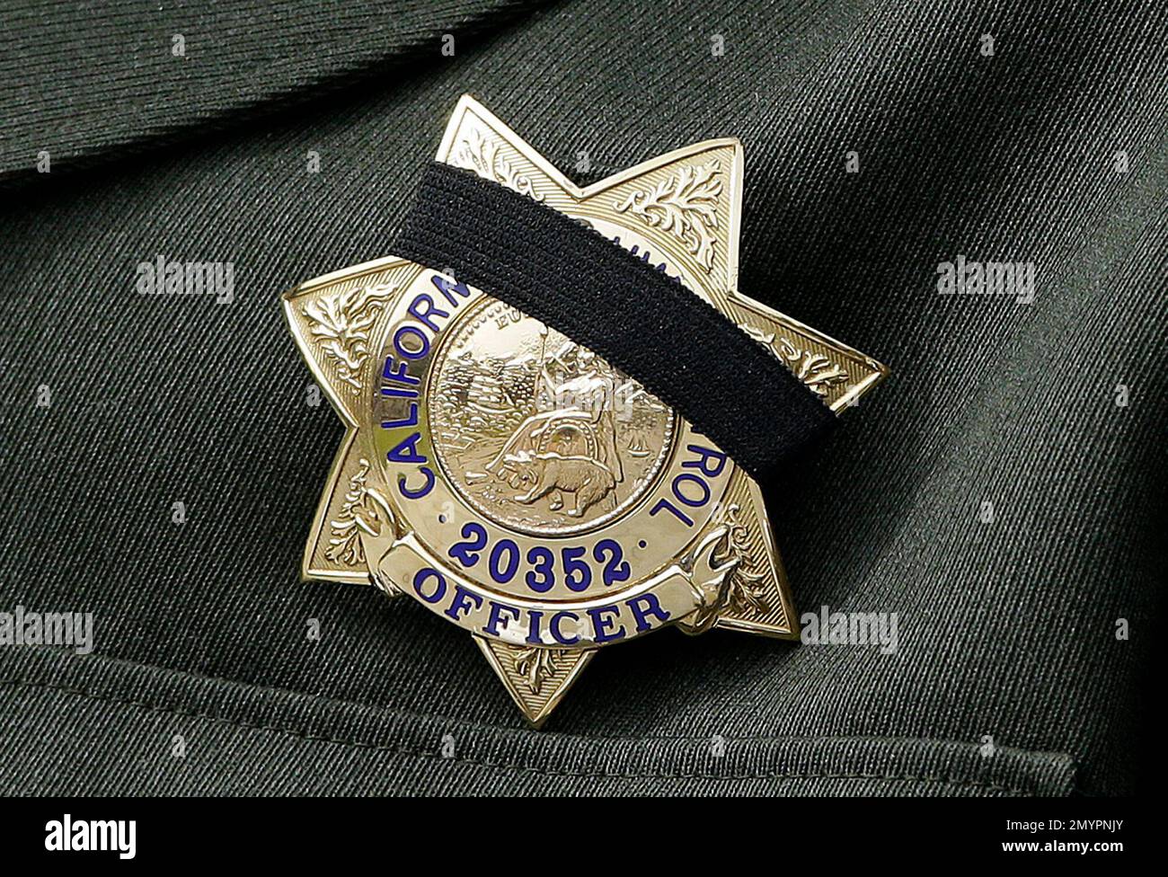 A black band crosses the badge of California Highway Patrol Officer ...