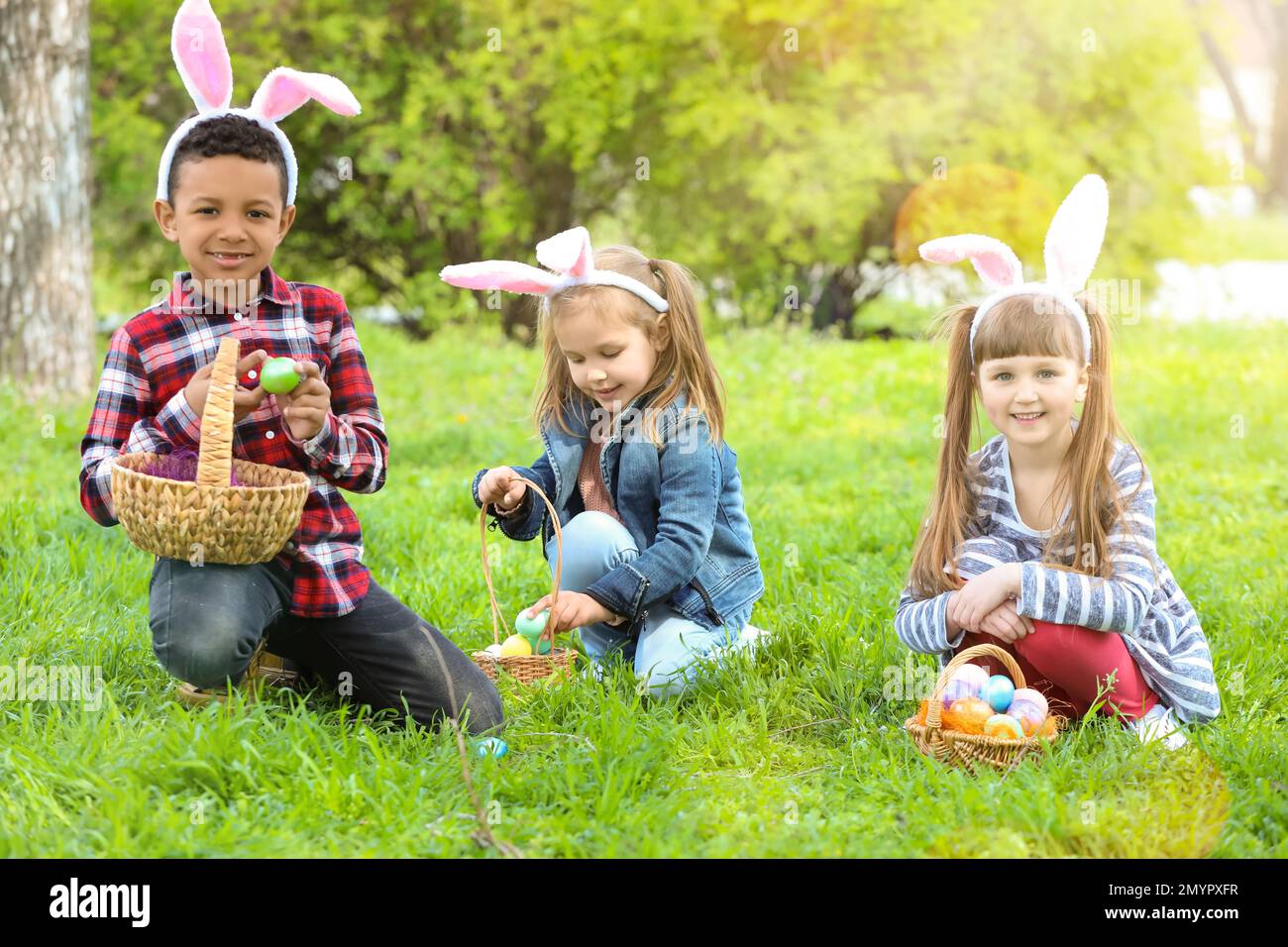 Cute little children gathering Easter eggs in spring park Stock Photo ...