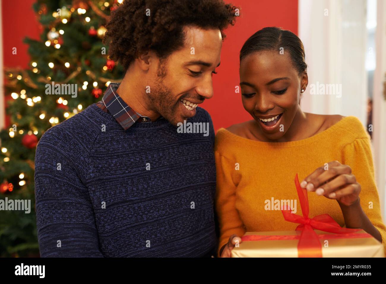 Feeling special on Christmas. a young woman opening her Christmas ...